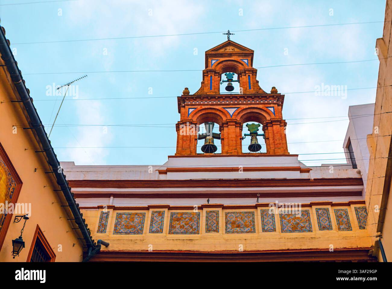 Bell tower adorned with three bells, standing out against a cloudy sky ...