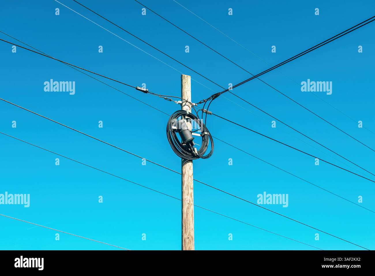 Landline telephone cable and wooden post against blue sky Stock Photo ...