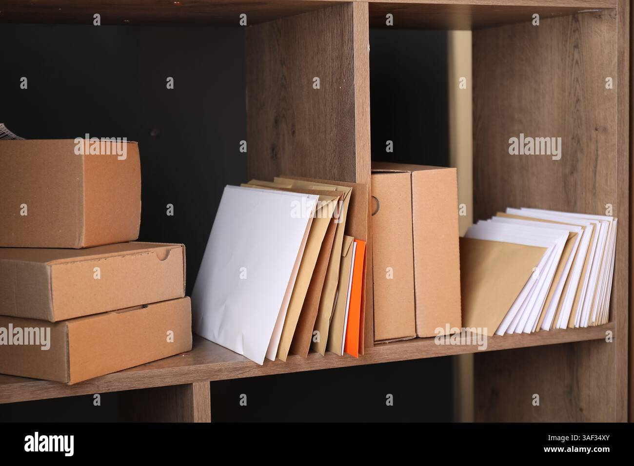 Different paper envelopes and parcels on wooden shelves in post office ...