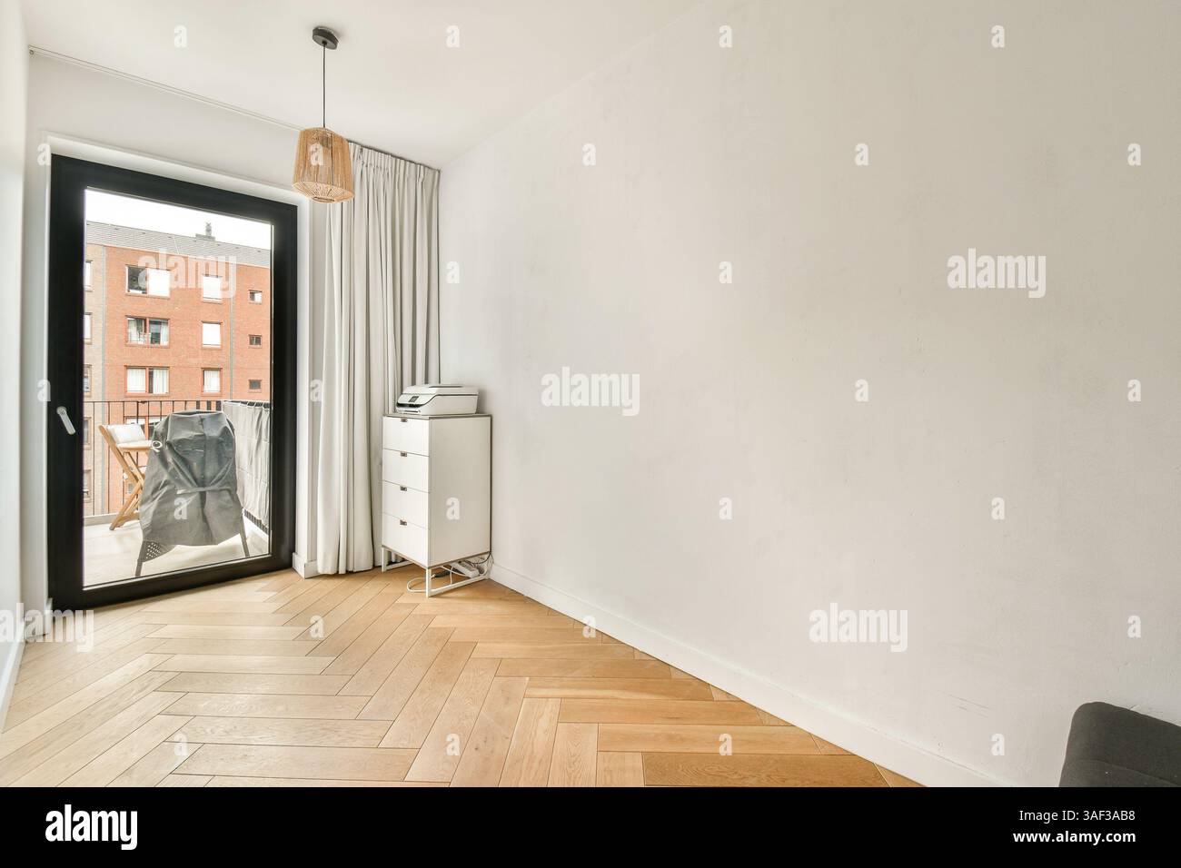 A clean, modern interior featuring wooden flooring and large windows ...