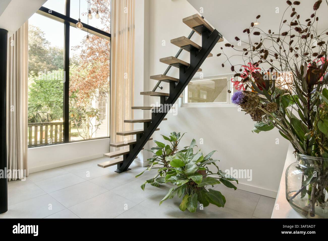 A contemporary interior featuring a sleek staircase, large windows, and ...