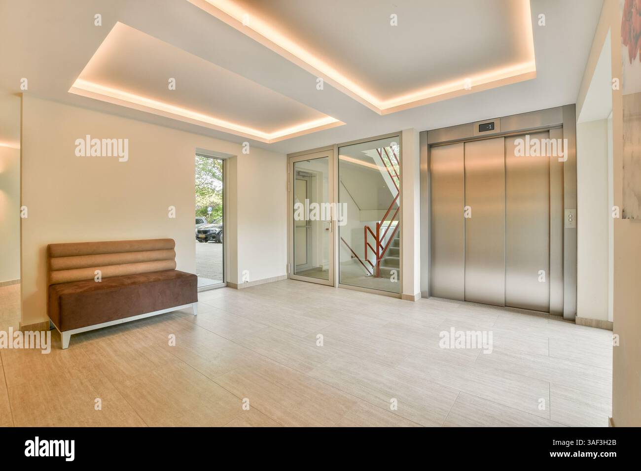 A spacious and well-lit modern entrance featuring a sleek elevator ...