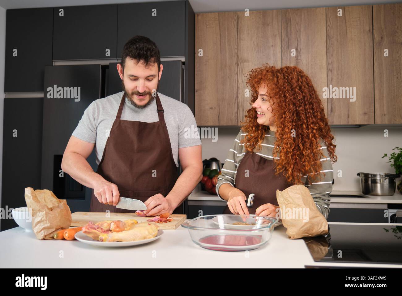 Chefs preparing chicken and red meat in modern kitchen Stock Photo - Alamy