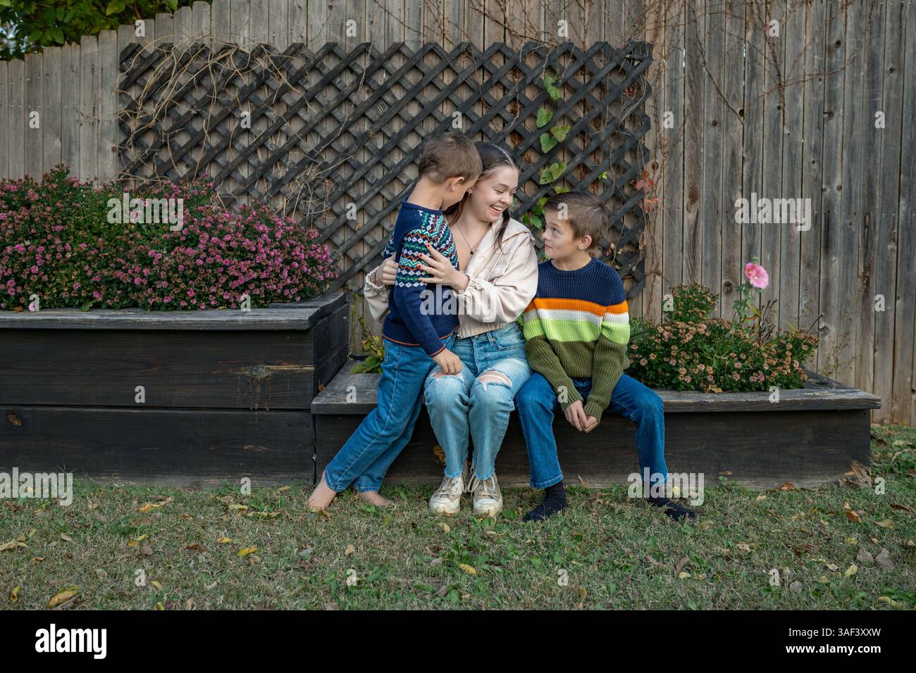Three siblings laughing and interacting outdoors Stock Photo - Alamy