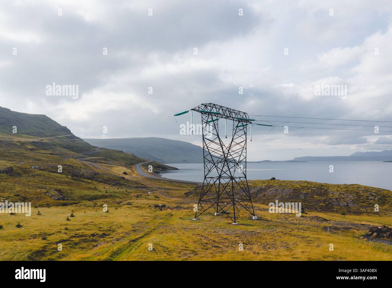 Electricity pylon in scenic landscape with lake Stock Photo - Alamy