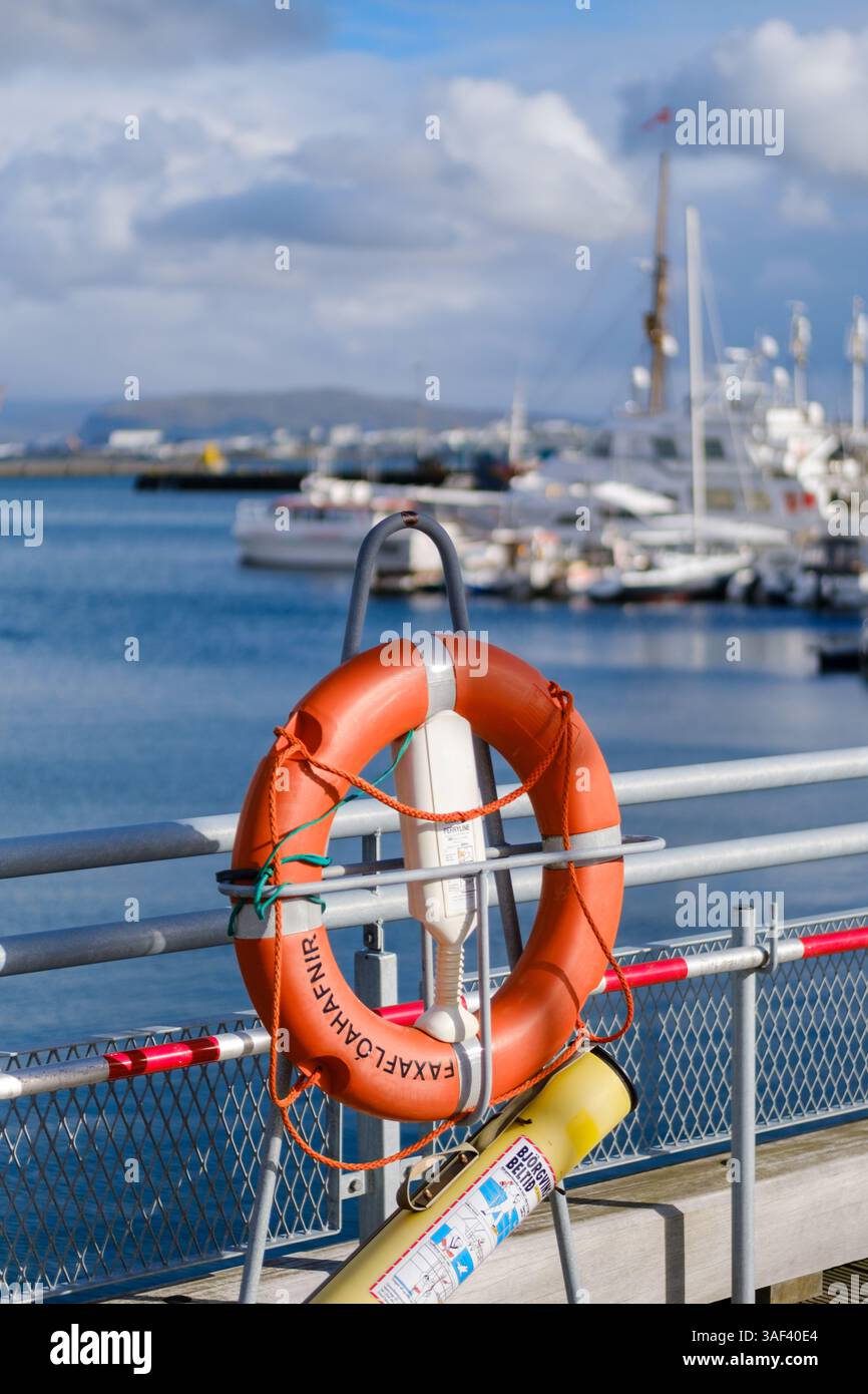 A life preserver on a railing next to a body of water Stock Photo - Alamy