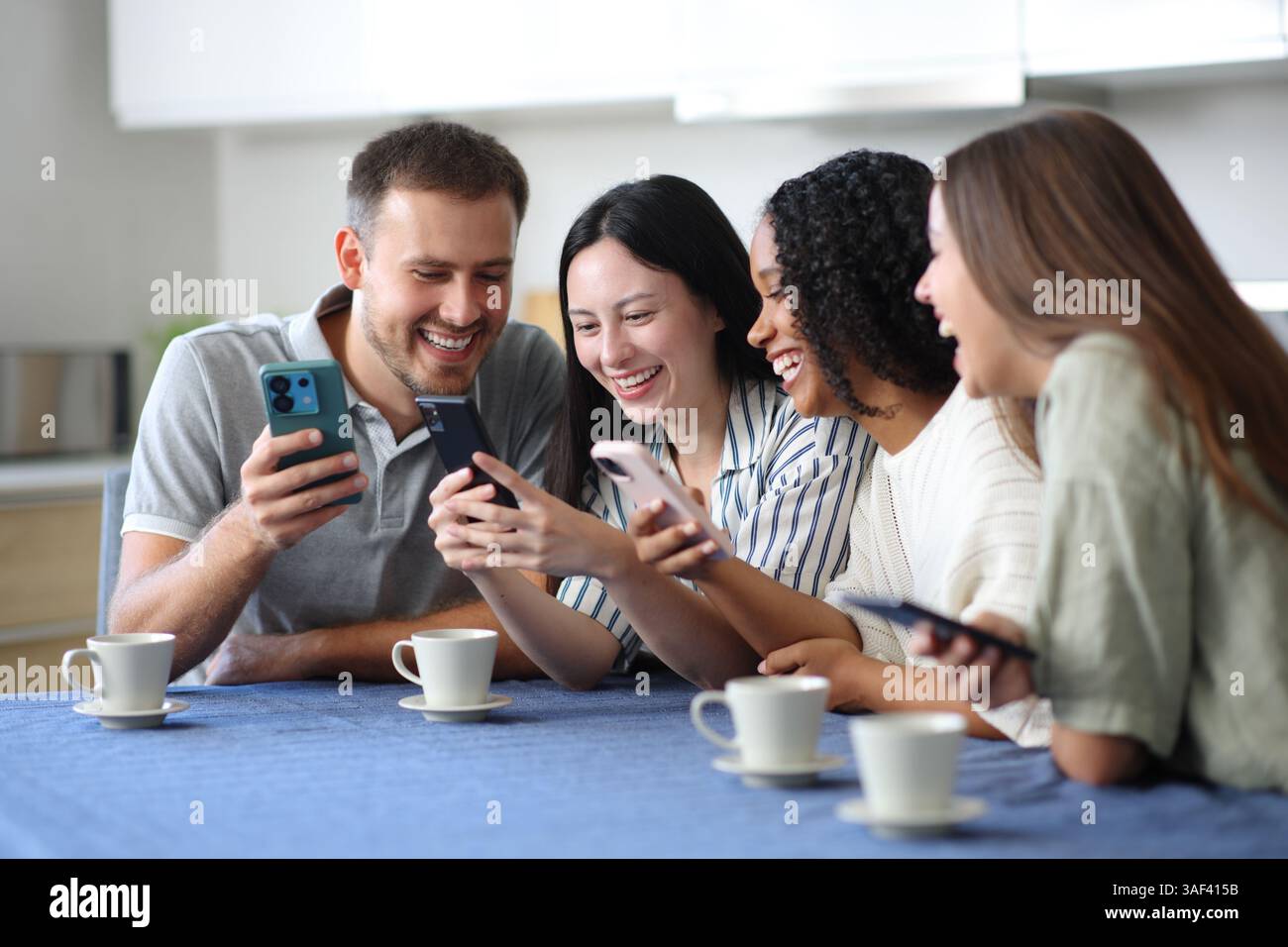 Young friends checking mobile devices hi-res stock photography and images - Alamy