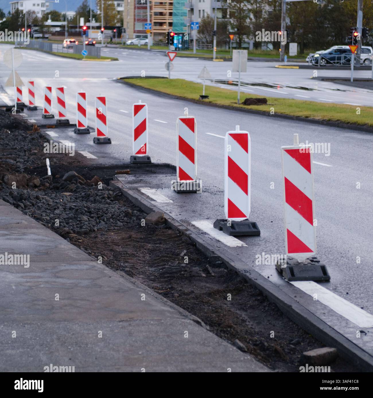 A road with red and white striped signs Stock Photo - Alamy