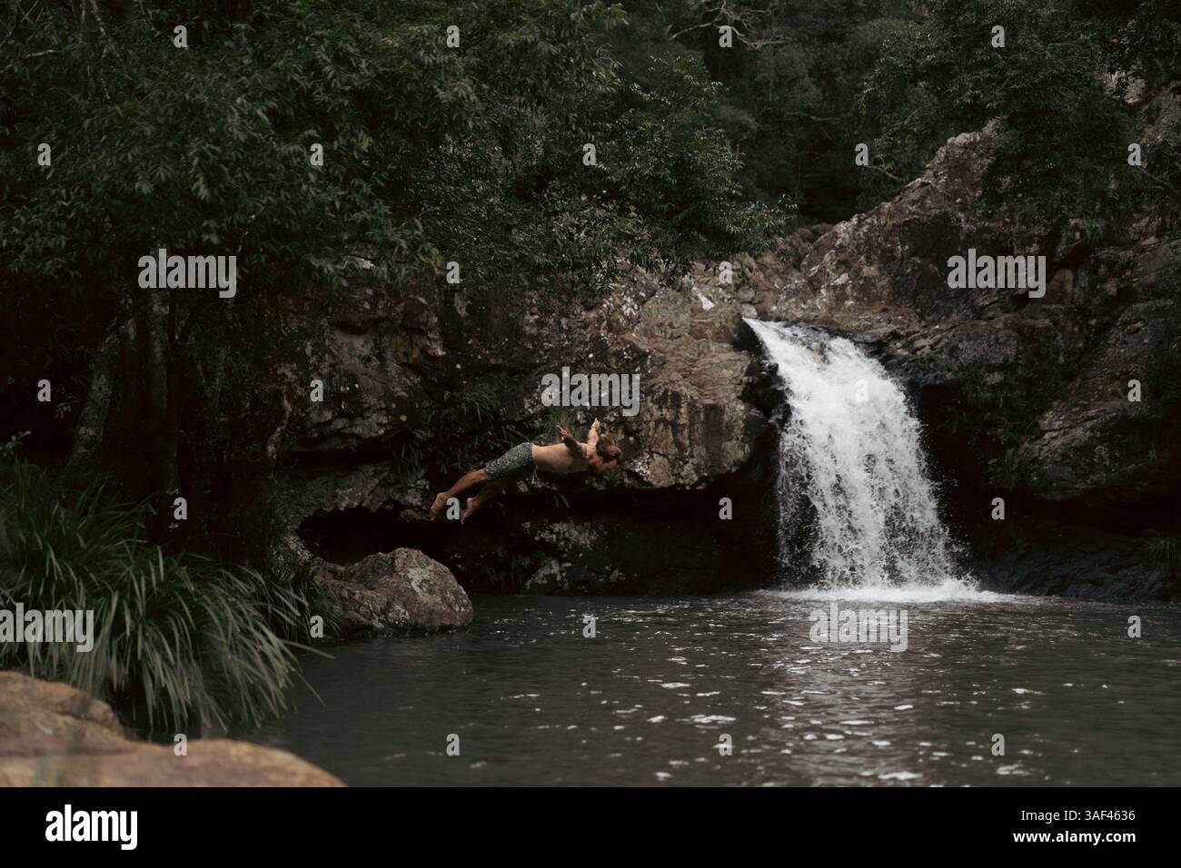 Man jumping into a waterfall Stock Photo - Alamy