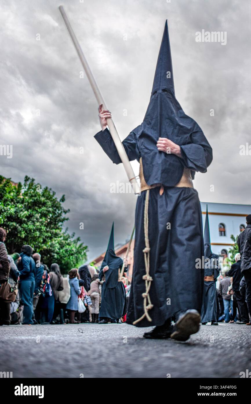 In Seville during Holy Week, a Nazareno in traditional robes holds a ...