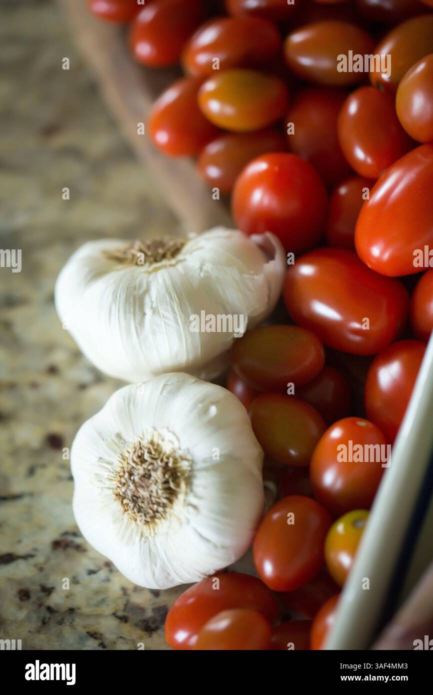Garlic bulbs and cherry tomatoes on a kitchen countertop Stock Photo ...