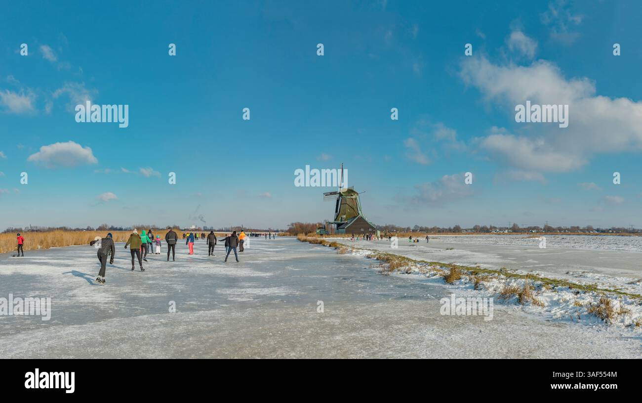 Scating on a frozen canal near a windmill Stock Photo - Alamy