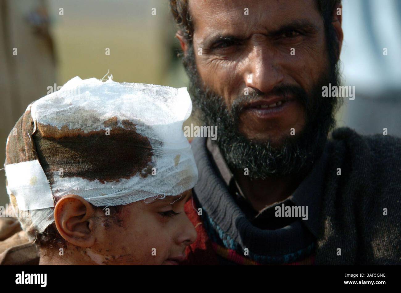 Oct 17, 2005; Northern Pakistan, PAKISTAN; A Pakistani father carries ...