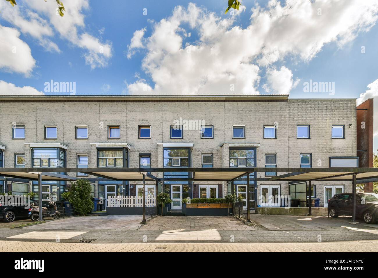 A striking modern residential building featuring a row of carports ...