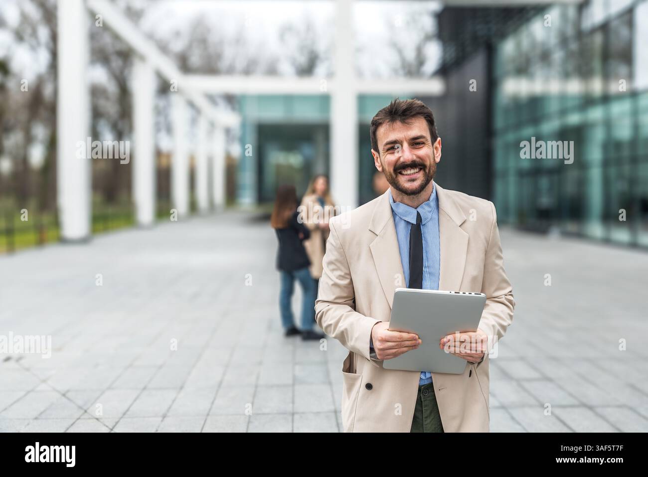Portrait of young successful businessman wearing stylish suit using ...