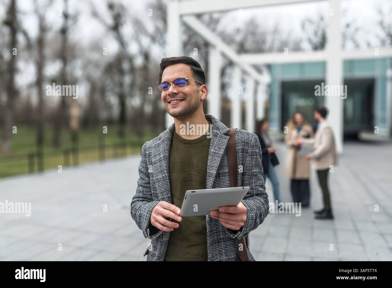 Portrait of young successful businessman wearing stylish suit using ...