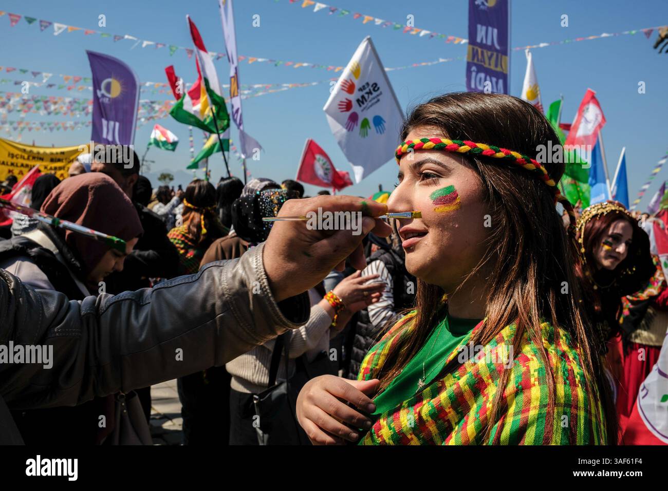 Izmir, Turkey. 22nd Mar, 2025. A woman paints her face with colors ...