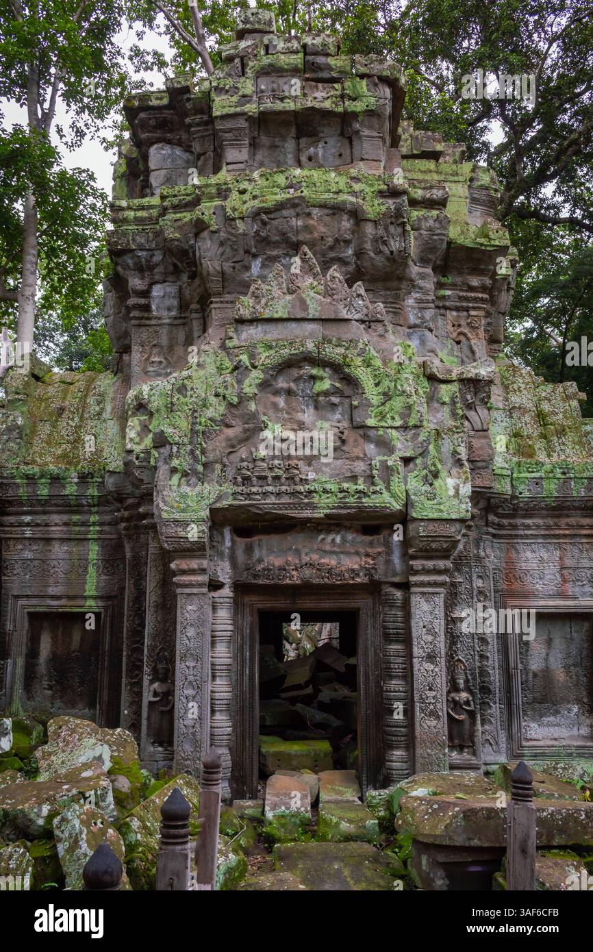 Green moss-covered stone building entrance and bricks at Ta Prohm Tomb ...
