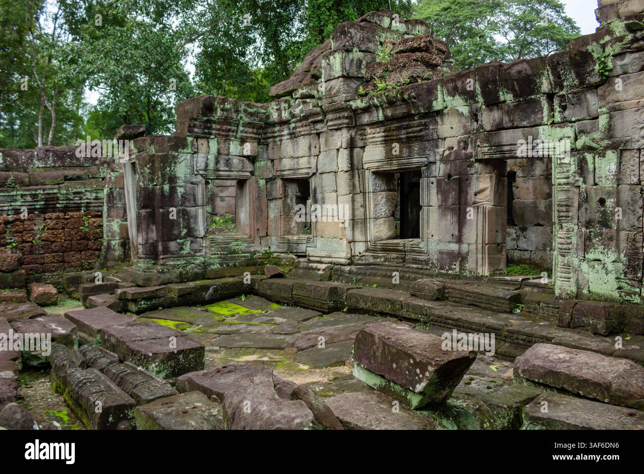 Moss covered green stone temple exterior and bricks at the Ta Prohm ...