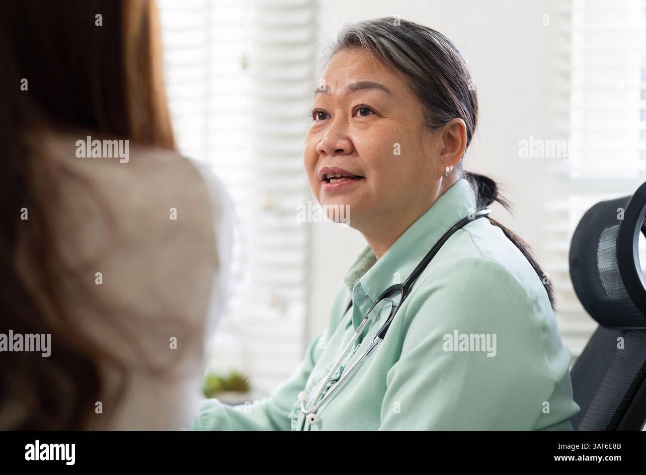 Patient Interaction and Healthcare. A senior doctor engaging in ...