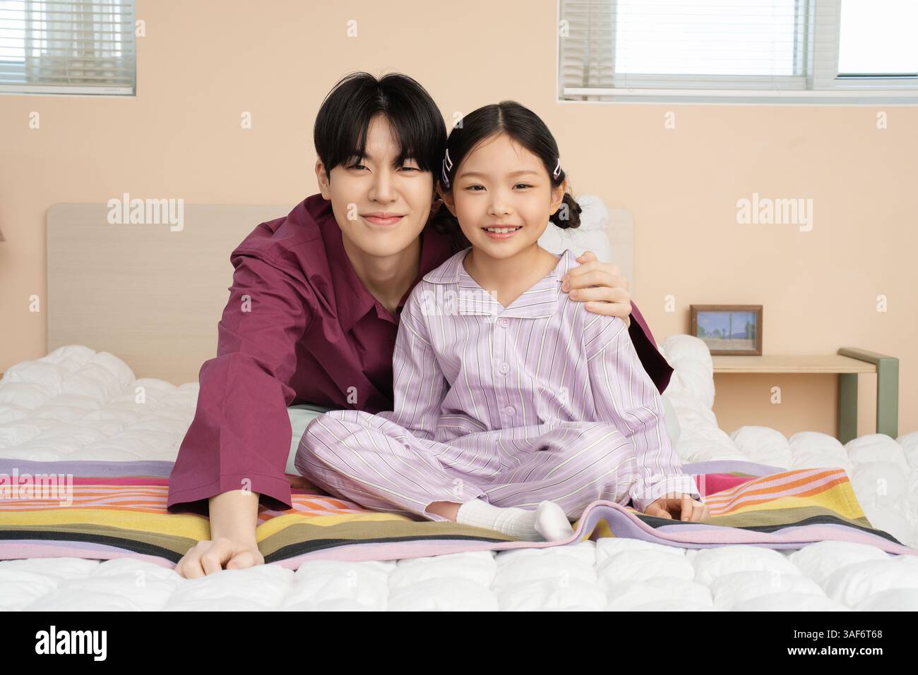 Dad sitting on bed with daughter Stock Photo - Alamy