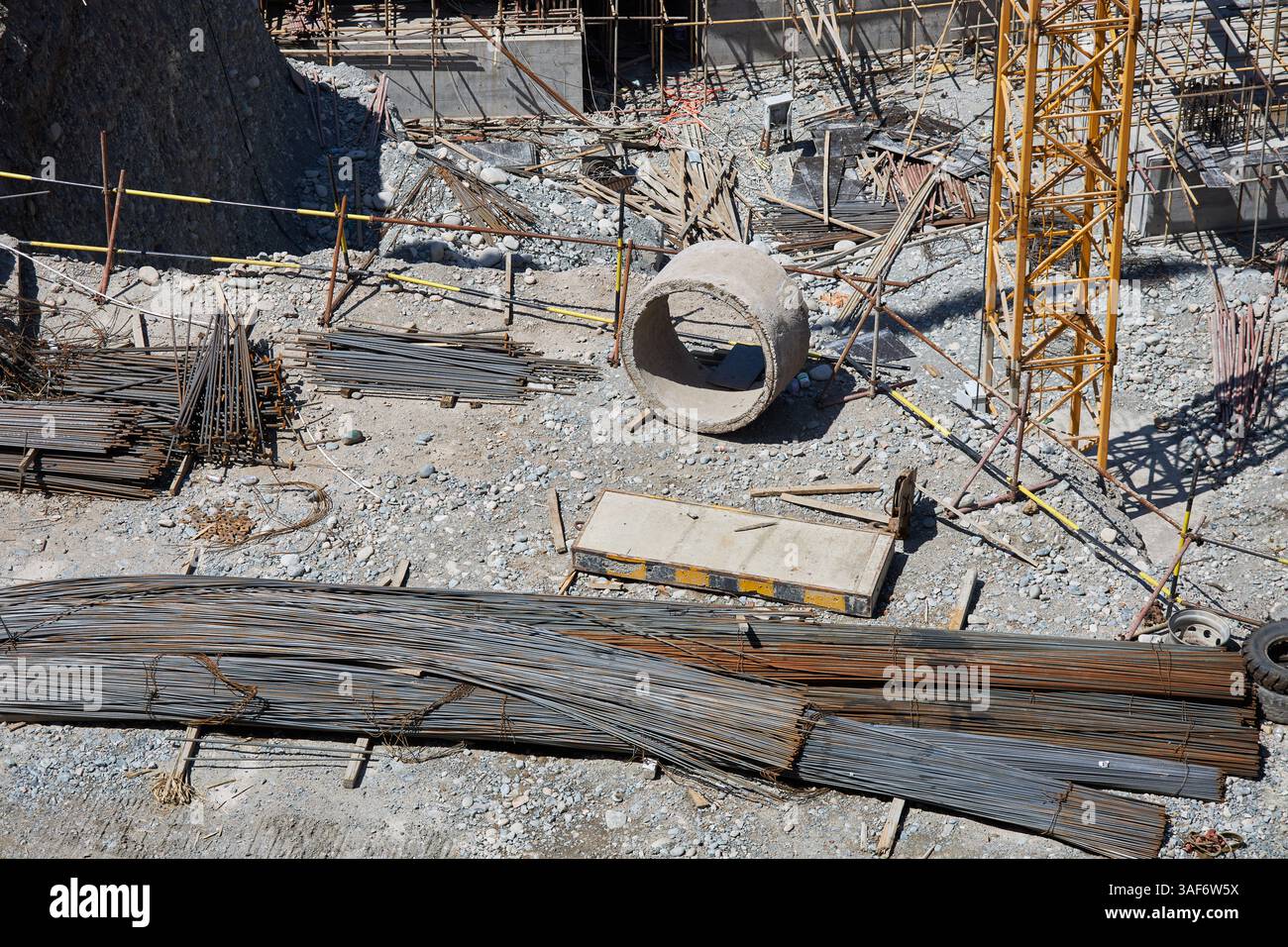 Construction site materials: concrete ring, reinforcement, crane part ...