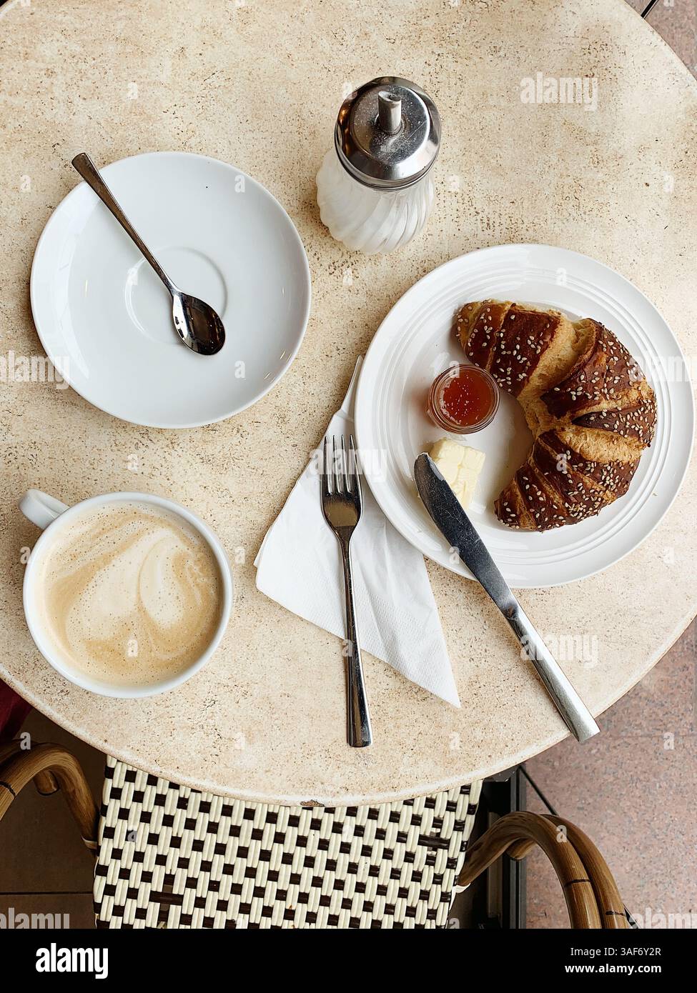 Top view of a typical french cafe breakfast, a croissant with jam and ...