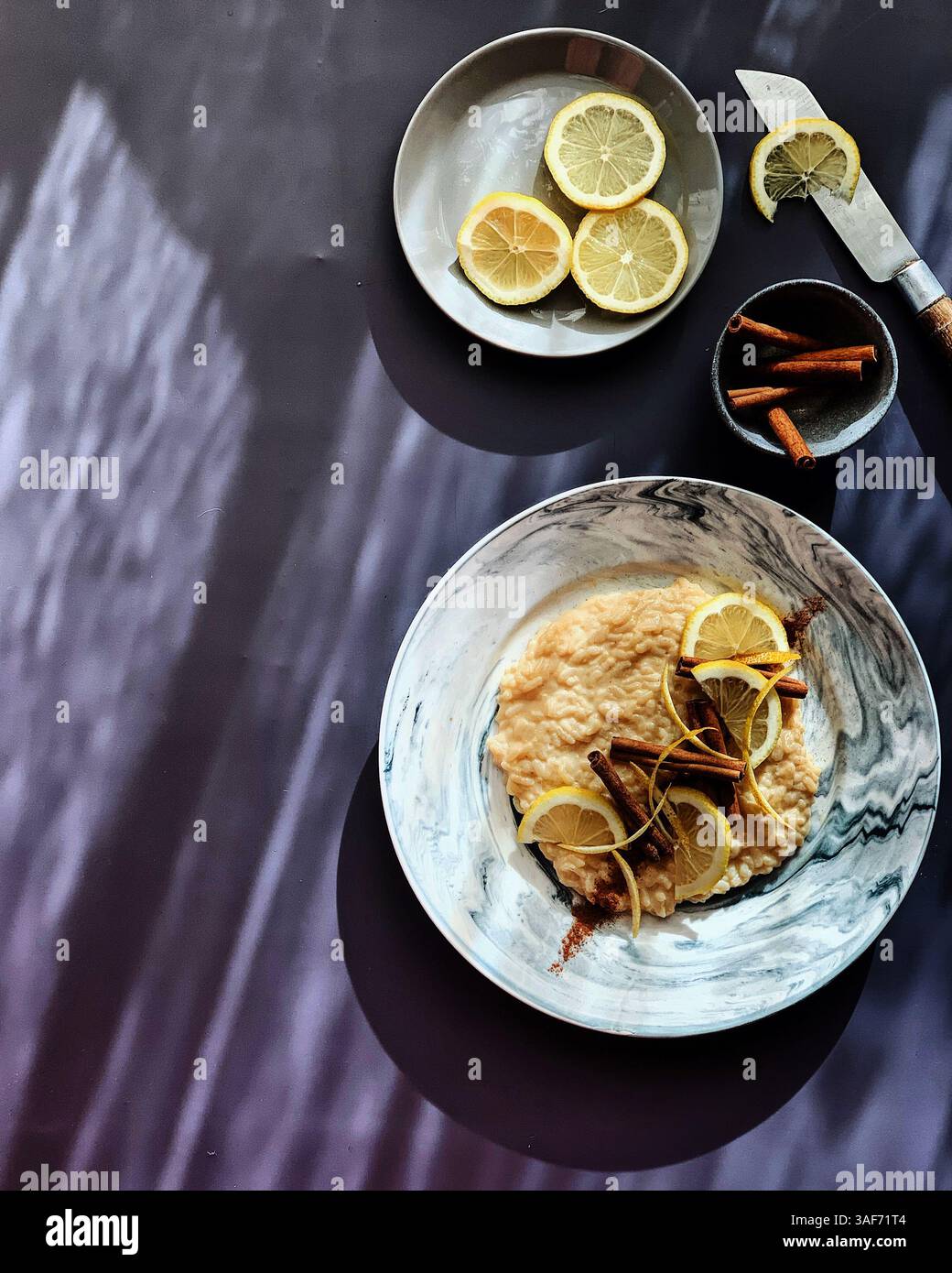 Classic creamy rice pudding decorated with sliced lemon and cinnamon ...
