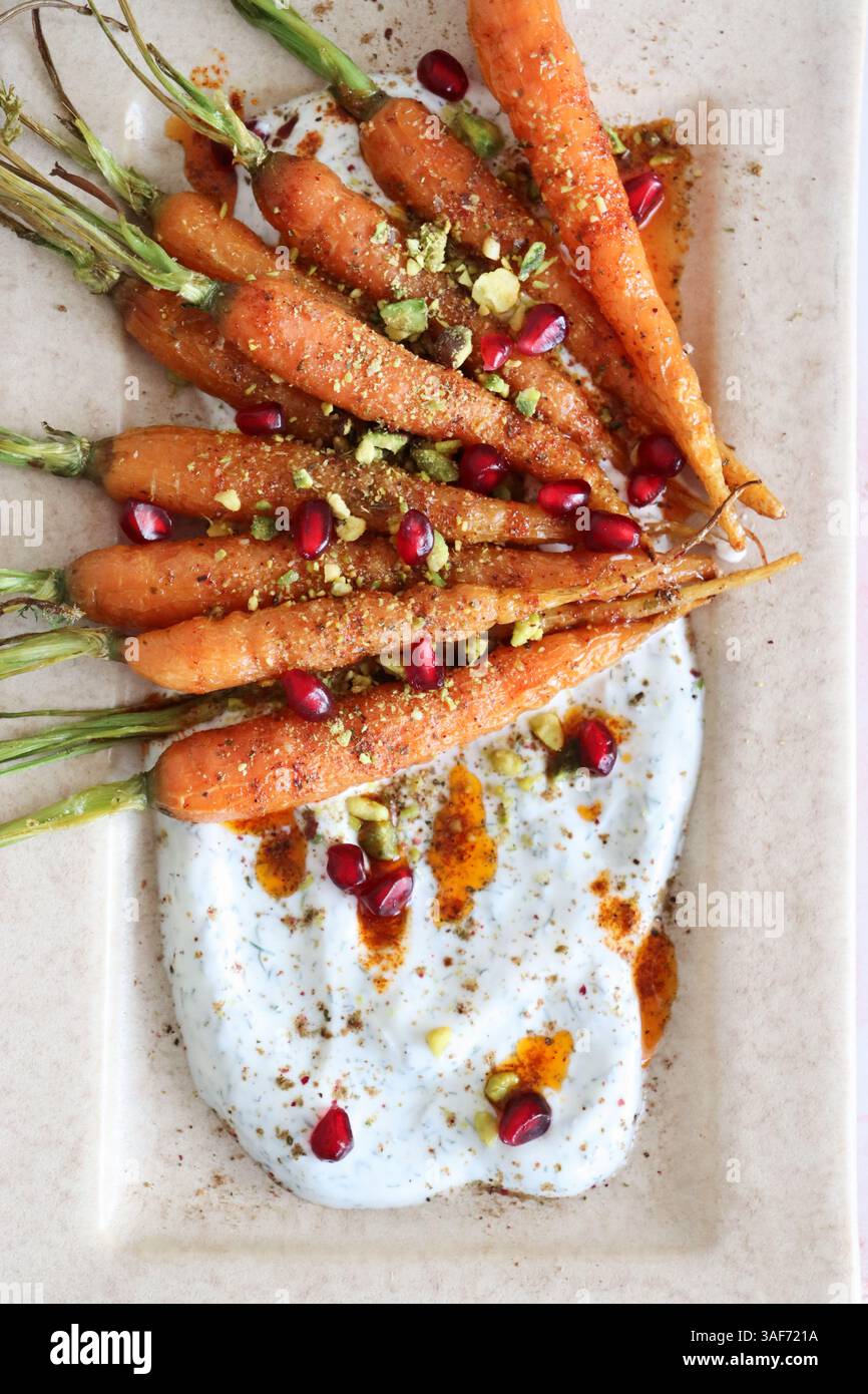 roasted small carrots with yogurt dip sauce decorated with pistachio ...