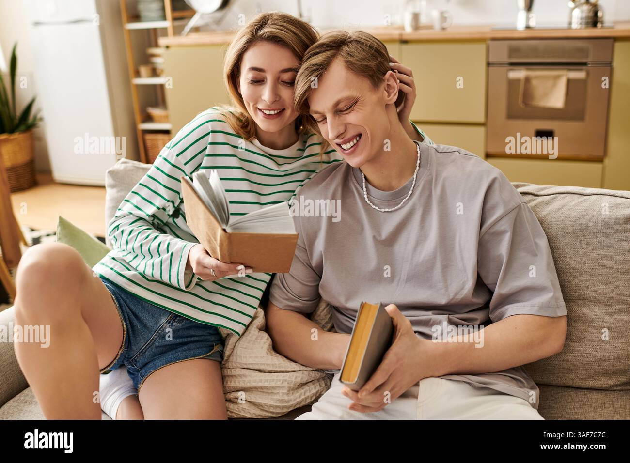 A loving couple laughs and shares a joyful moment while reading books ...