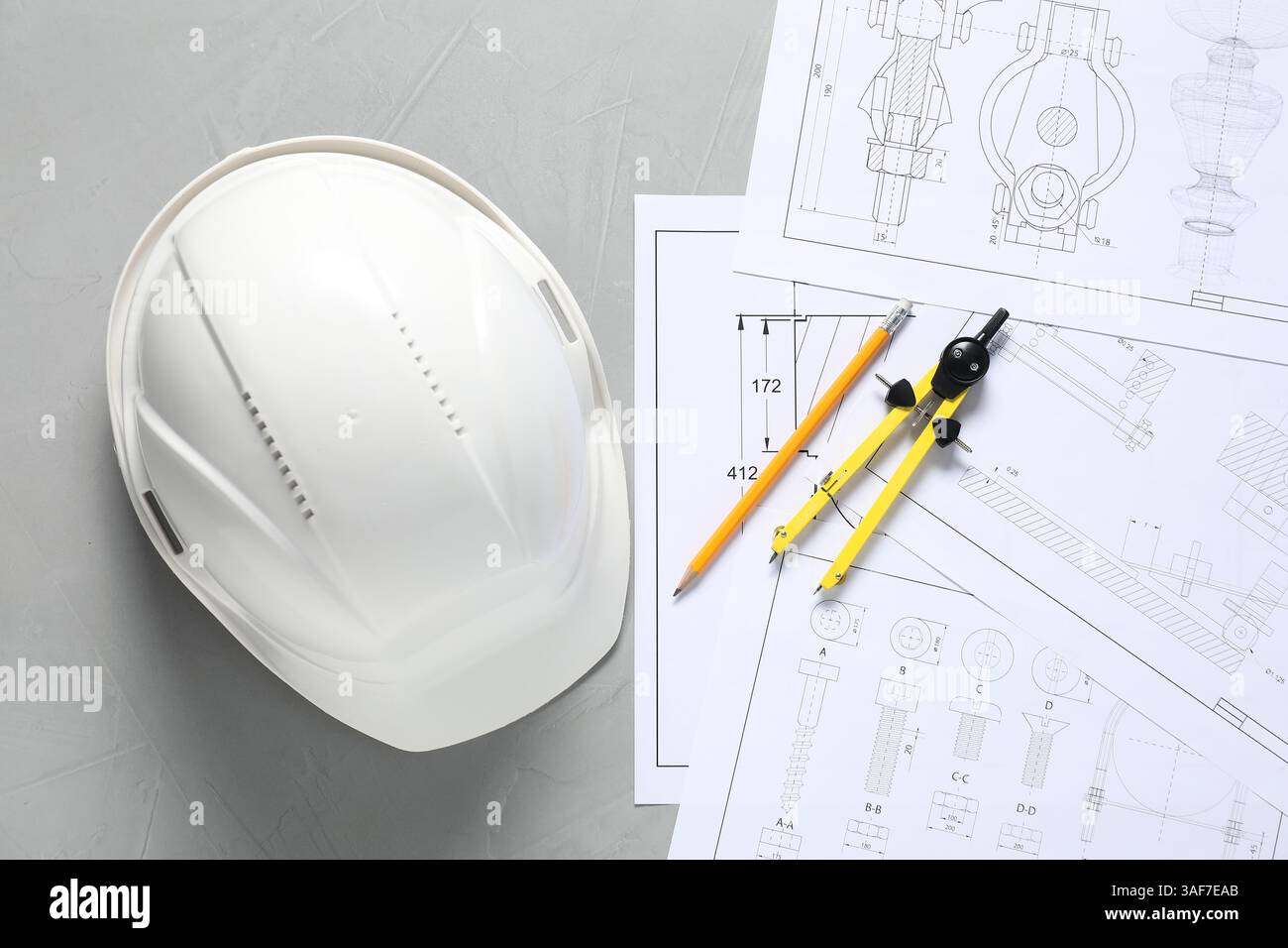 Different engineering drawings, hard hat, pencil and divider on grey ...