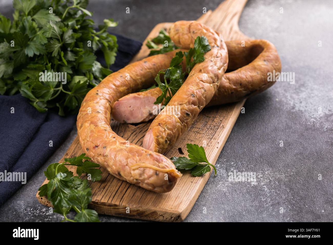 Fresh Polish Kielbasa being sliced wiht a knife on a cutting board ...