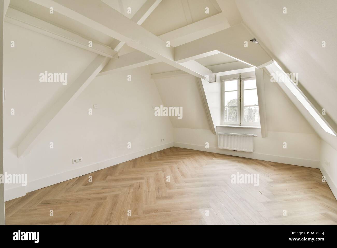 A modern attic interior with sloped ceilings, large windows, and wooden ...