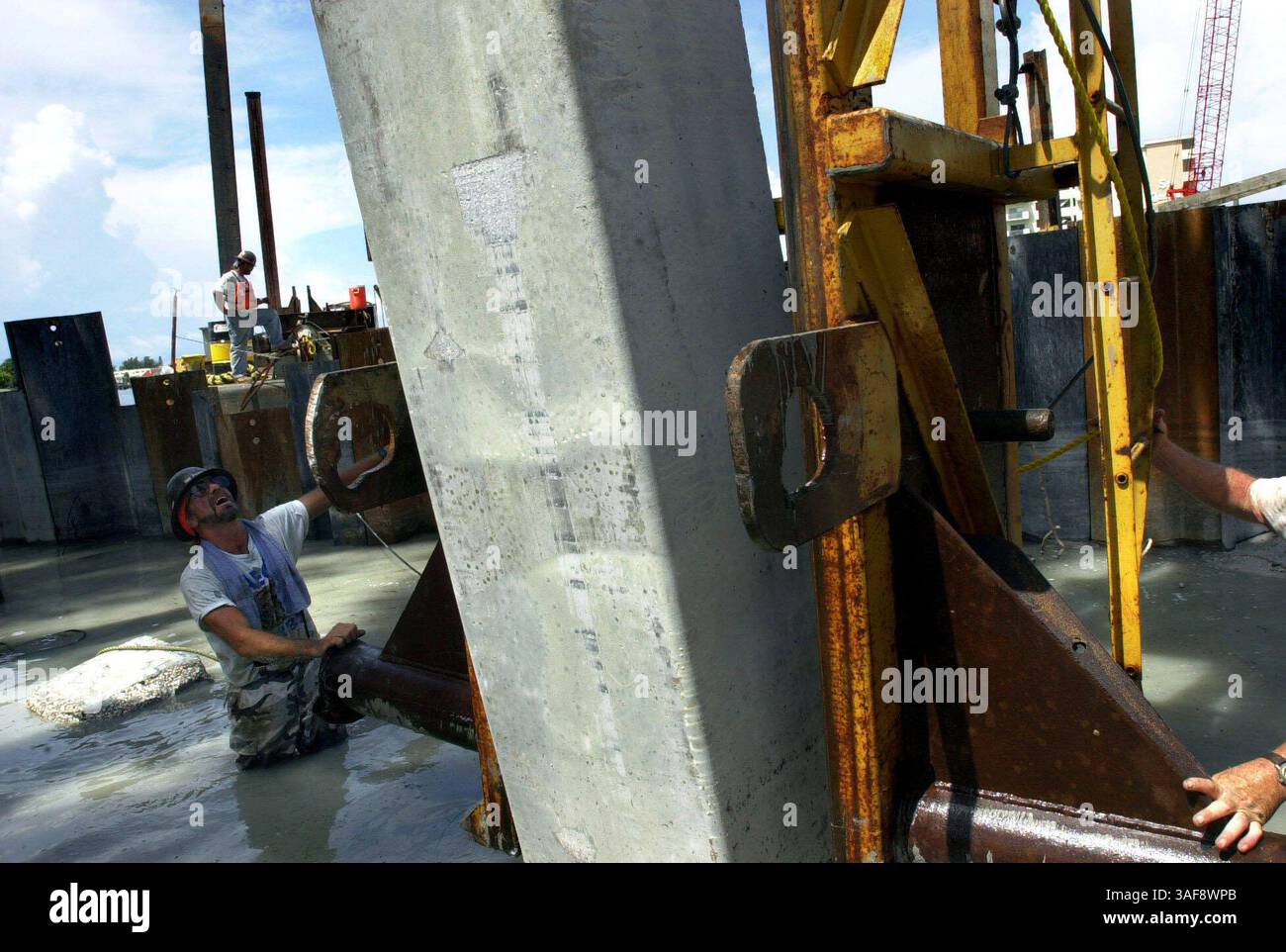Randy Marshall (cq) (center) works on driving a concrete pile for the ...