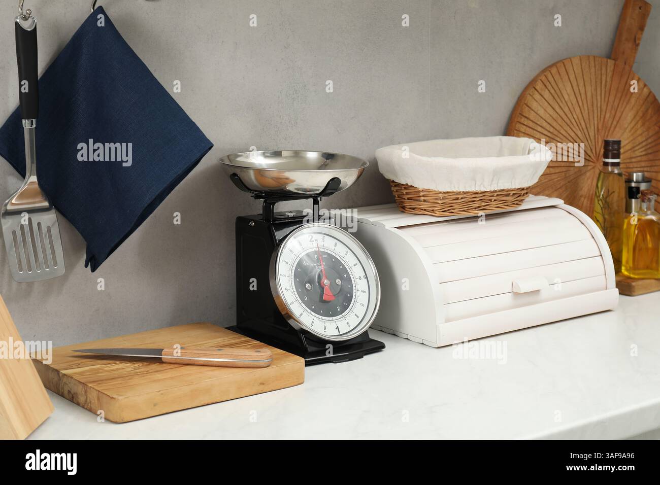 Retro mechanical kitchen scale and other utensils on white countertop ...