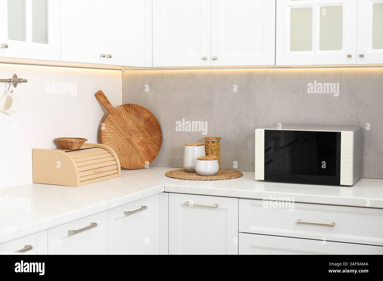 Closed microwave oven on counter in kitchen Stock Photo - Alamy