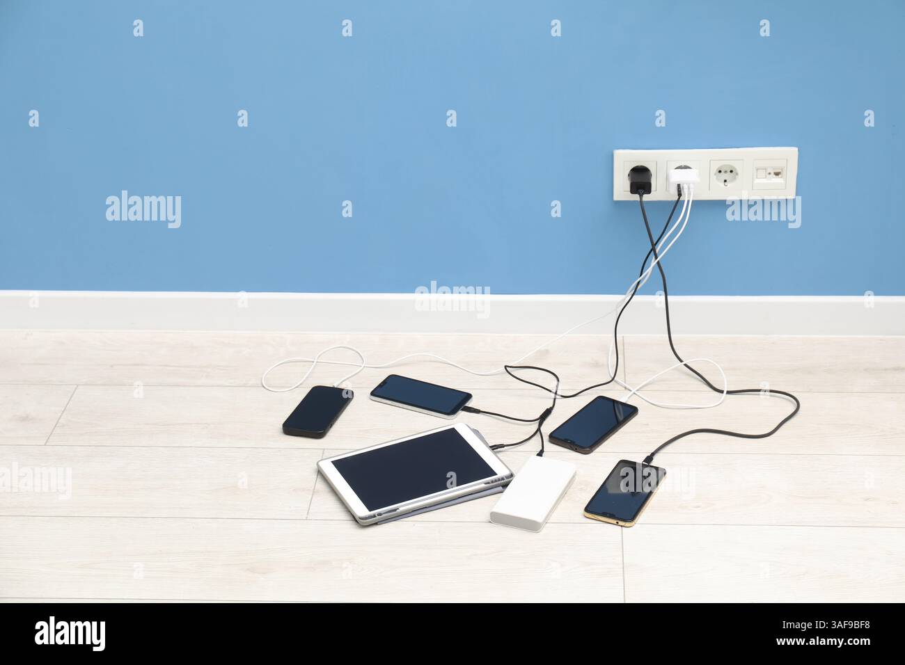 USB adapters with cables plugged into electric socket charging ...