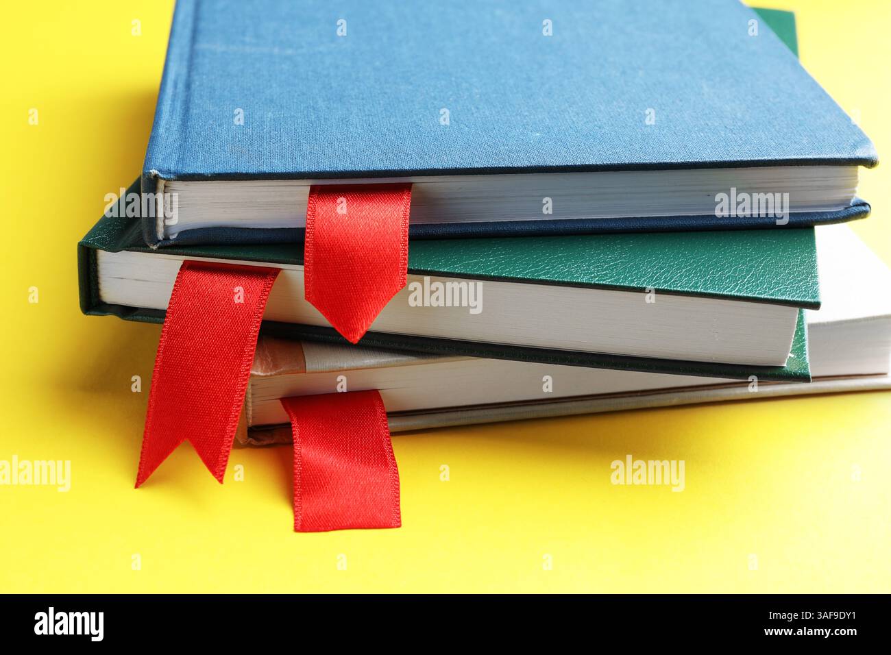 Books with red ribbon bookmarks on yellow background, closeup Stock ...