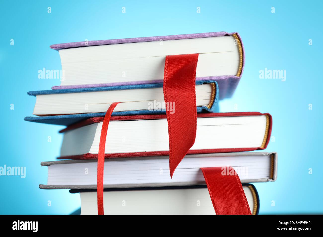 Books with red ribbon bookmarks on light blue background, closeup Stock ...