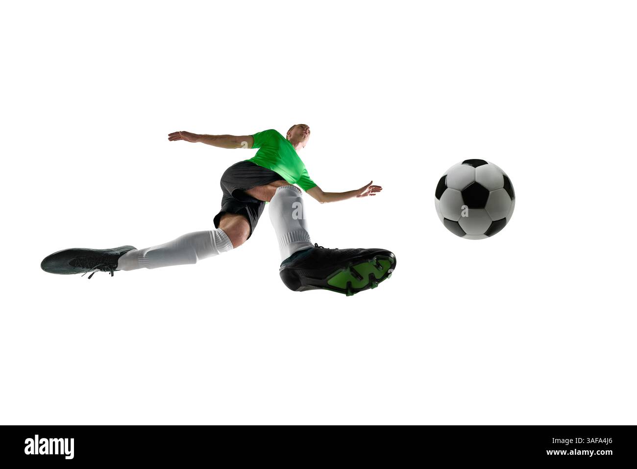 Low angle of football striker, dressed black and green sport uniform ...