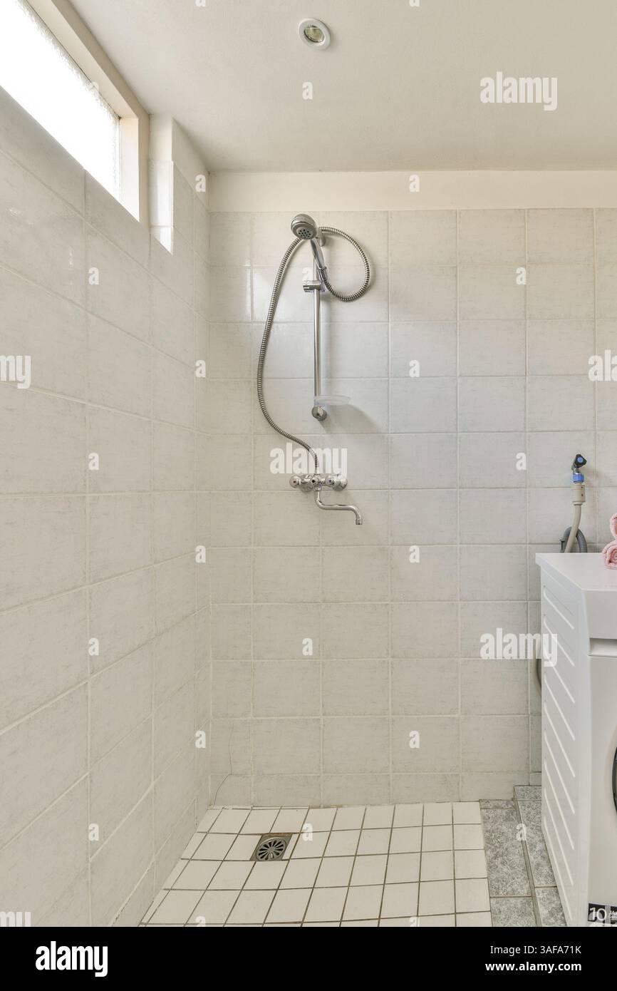 A clean and simple bathroom featuring tiled walls and a modern shower ...