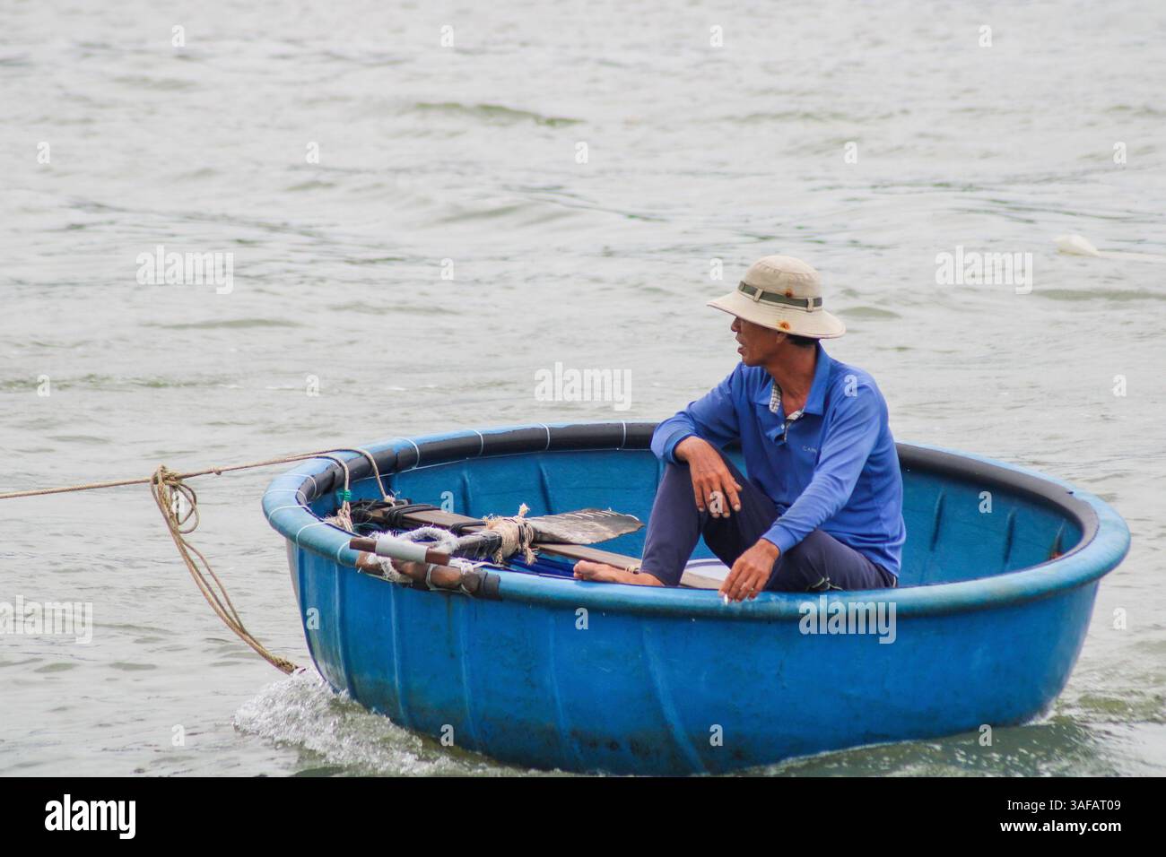 Phan Thiet, Vietnam. A fisherman on a traditional Vietnamese round ...