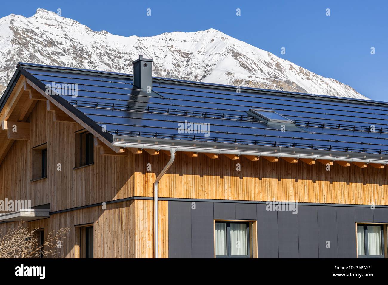 Swiss wooden house with solar modules on the roof and facade Stock ...