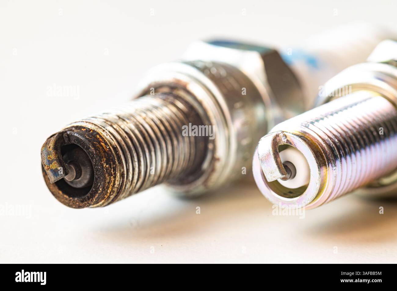 New and used spark plugs, for internal combustion engine, on white ...
