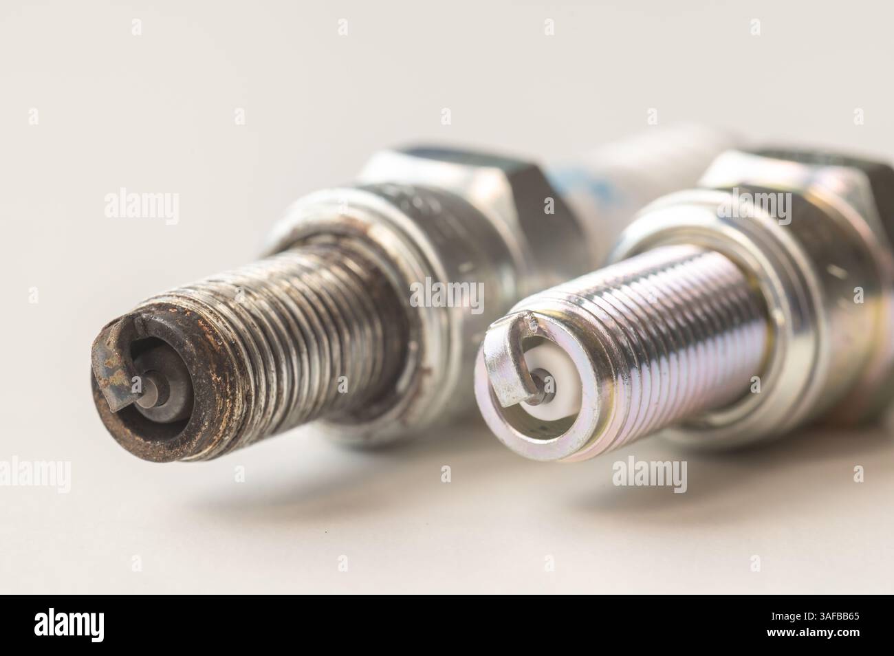 New and used spark plugs, for internal combustion engine, on white ...