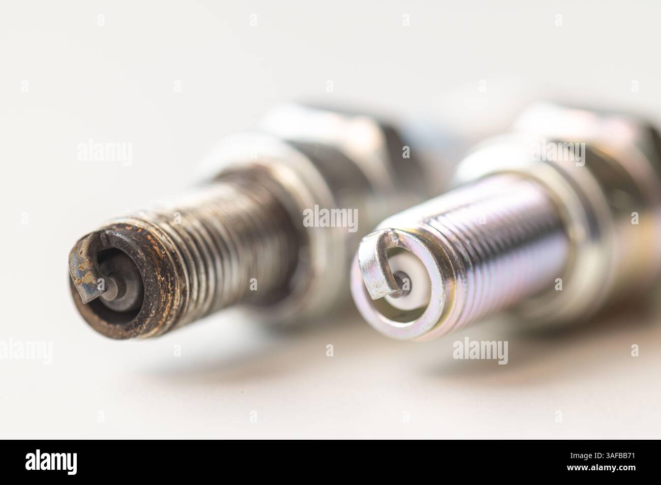 New and used spark plugs, for internal combustion engine, on white ...