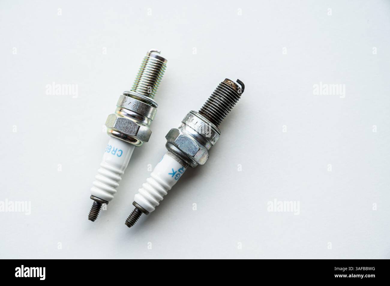 New and used spark plugs, for internal combustion engine, on white ...