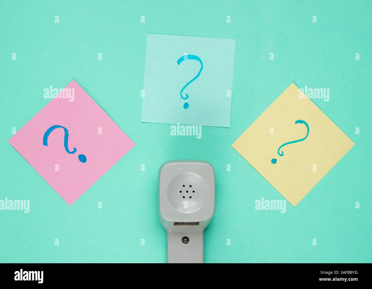 Retro handset and question marks on memo pieces of paper. Call center ...