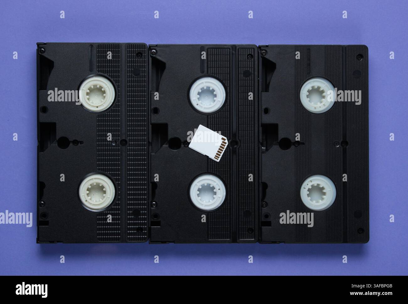 SD memory card, video cassette on purple paper background with ...