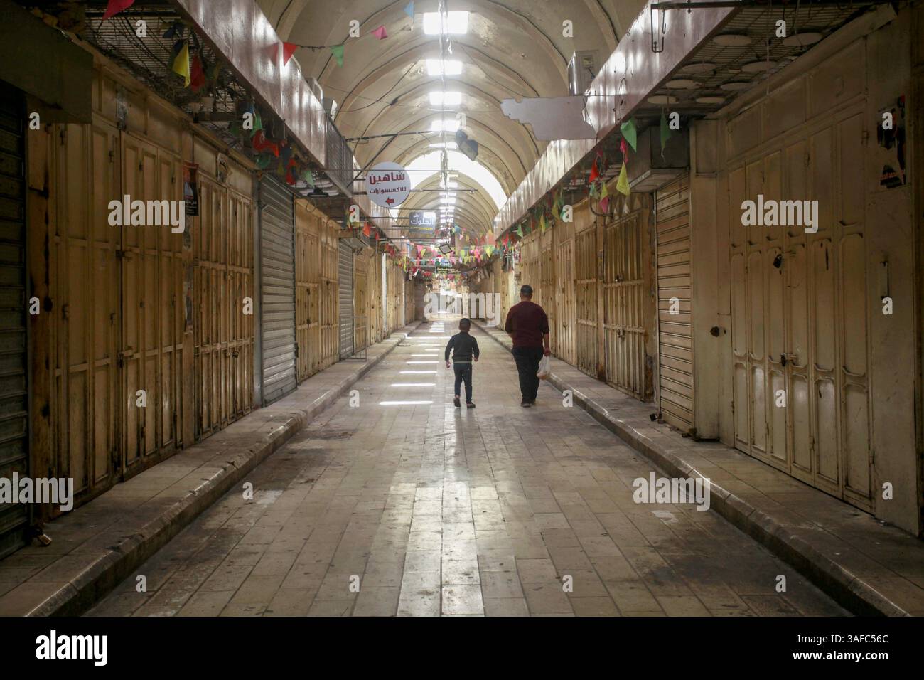 Nablus, Palestine. 07th Apr, 2025. A man and a child walk through a ...